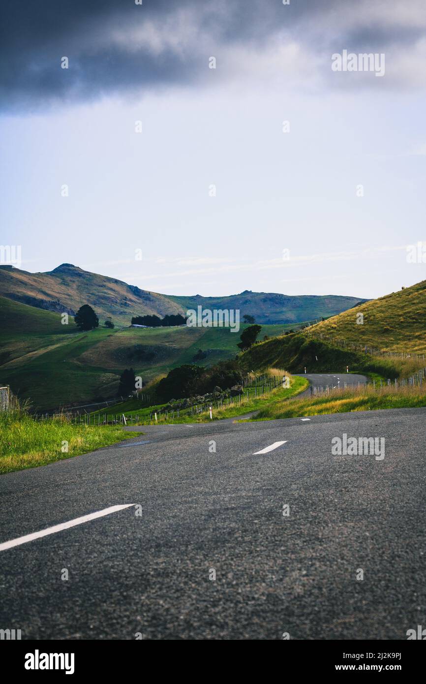 The long rural road leading to the mountains in Akaroa, New Zealand ...