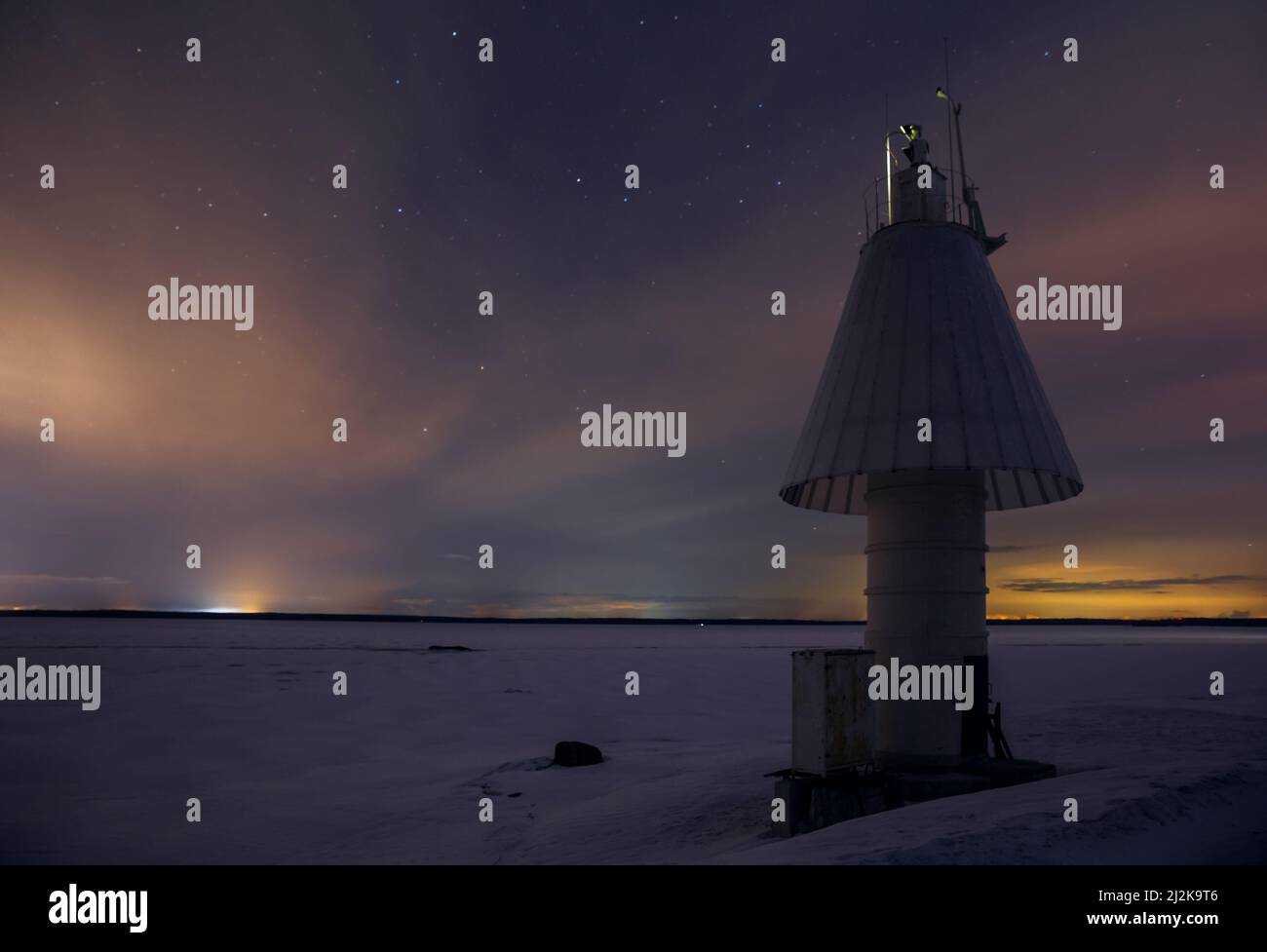 Night winter landscape. A starry multi-colored sky over a frozen bay ...