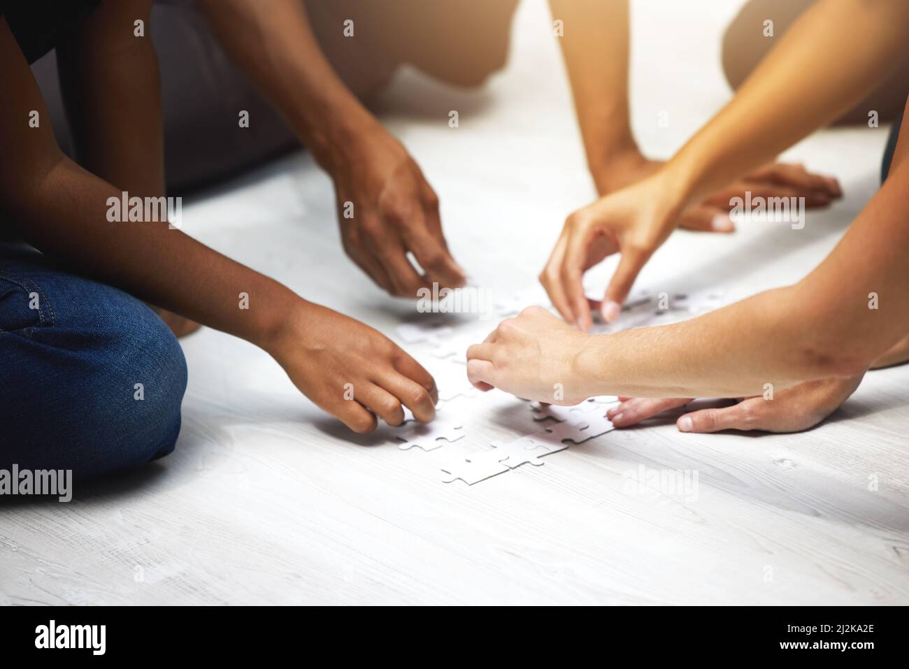Puzzles are fun to do together. Shot of a group of unrecognizable ...