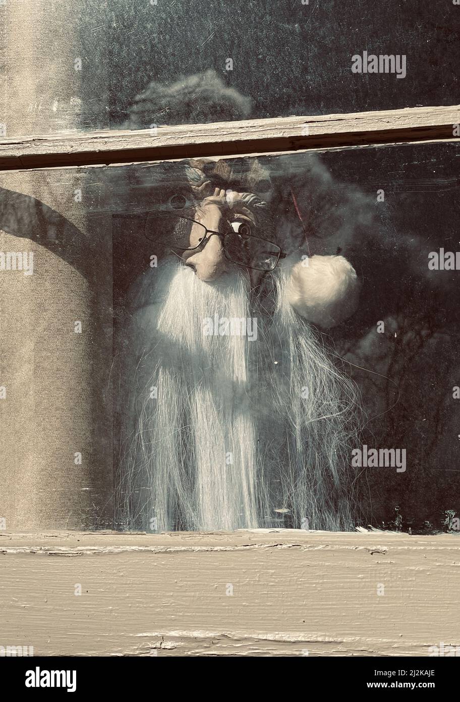 A creepy old face wearing a Santa hat lurking behind a window Stock ...