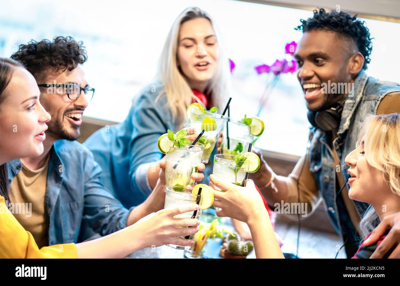 Trendy friends toasting mojito drinks at fancy cocktail bar restaurant ...