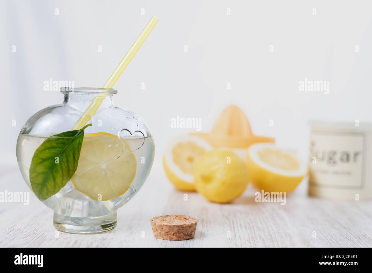 Heart-shaped pitcher with lemonade and cubes, a slice of lemon and a ...