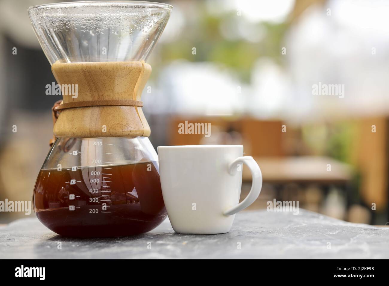 A closeup of a Chemex Coffeemaker near a white cup Stock Photo - Alamy