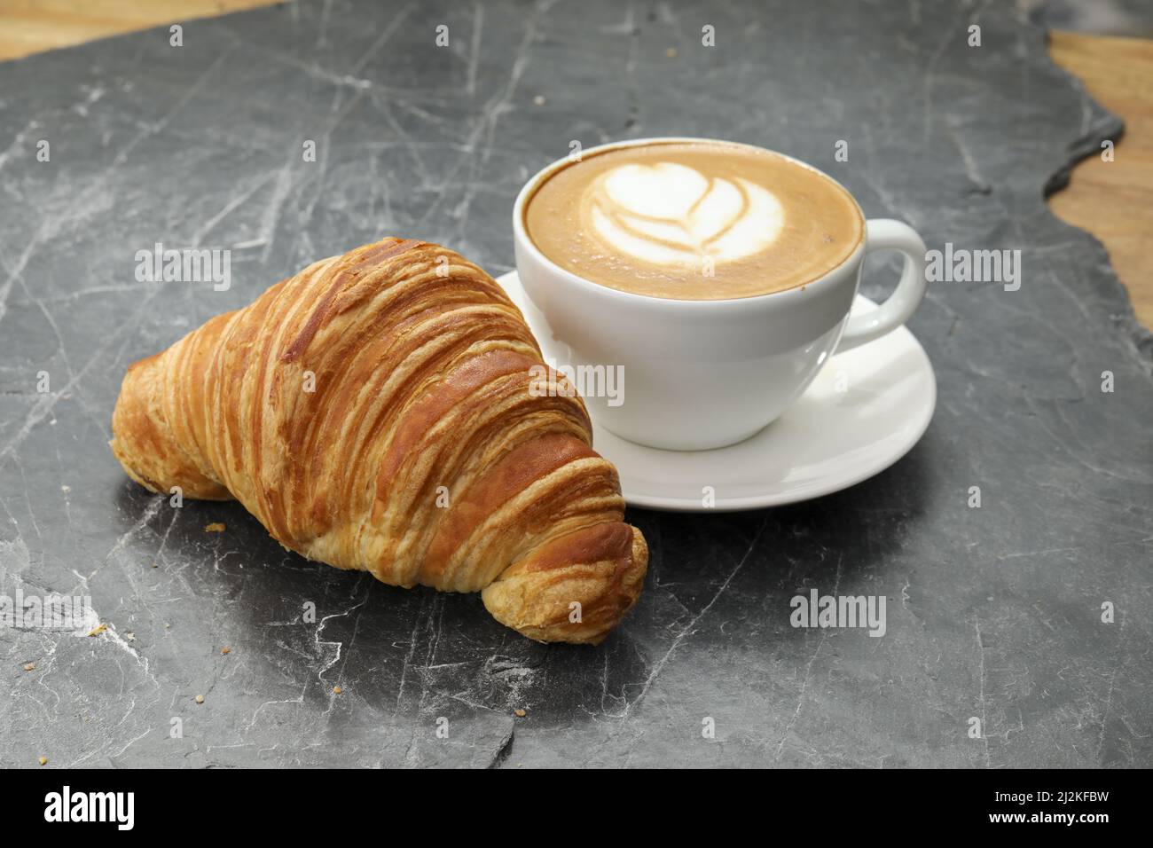 A closeup of a freshly baked croissant near a cup of coffee Stock Photo ...
