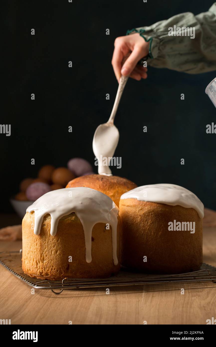 A girl smears Easter cakes with icing, photo in a rustic style Stock ...