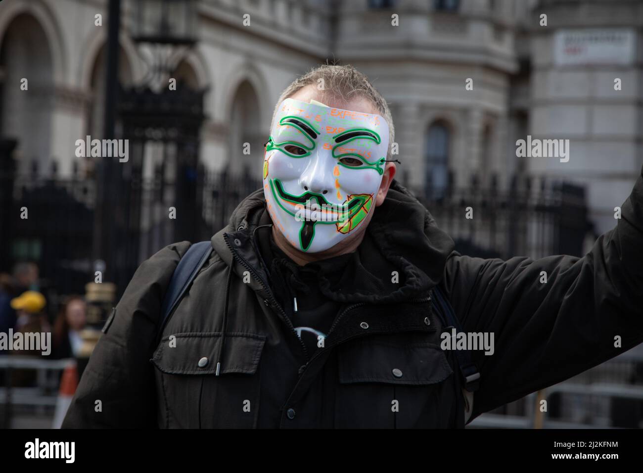 London, UK. 2 April 2022. A man wearing an Anonymous mask waves a flag ...