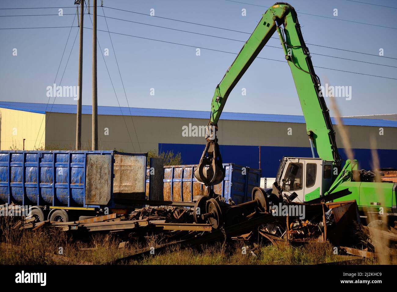 Crane loads dipper truck with scrap metal Stock Photo - Alamy