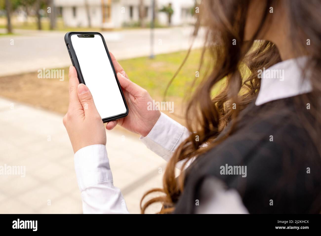 Over shoulder view of woman using phone. Taking photo, reading message ...
