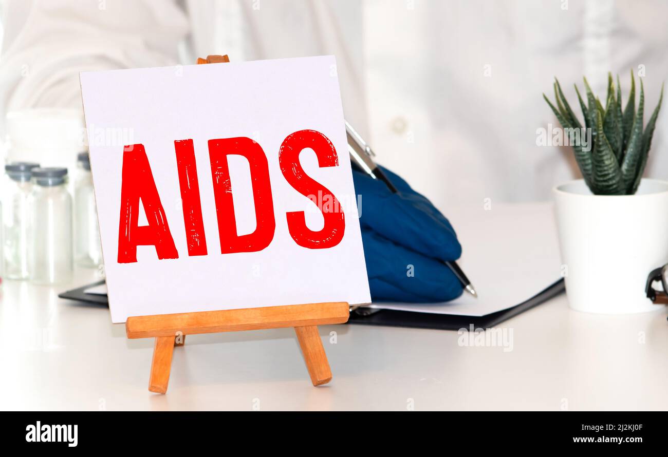 Doctor holding card in hands and pointing the word AID Stock Photo - Alamy
