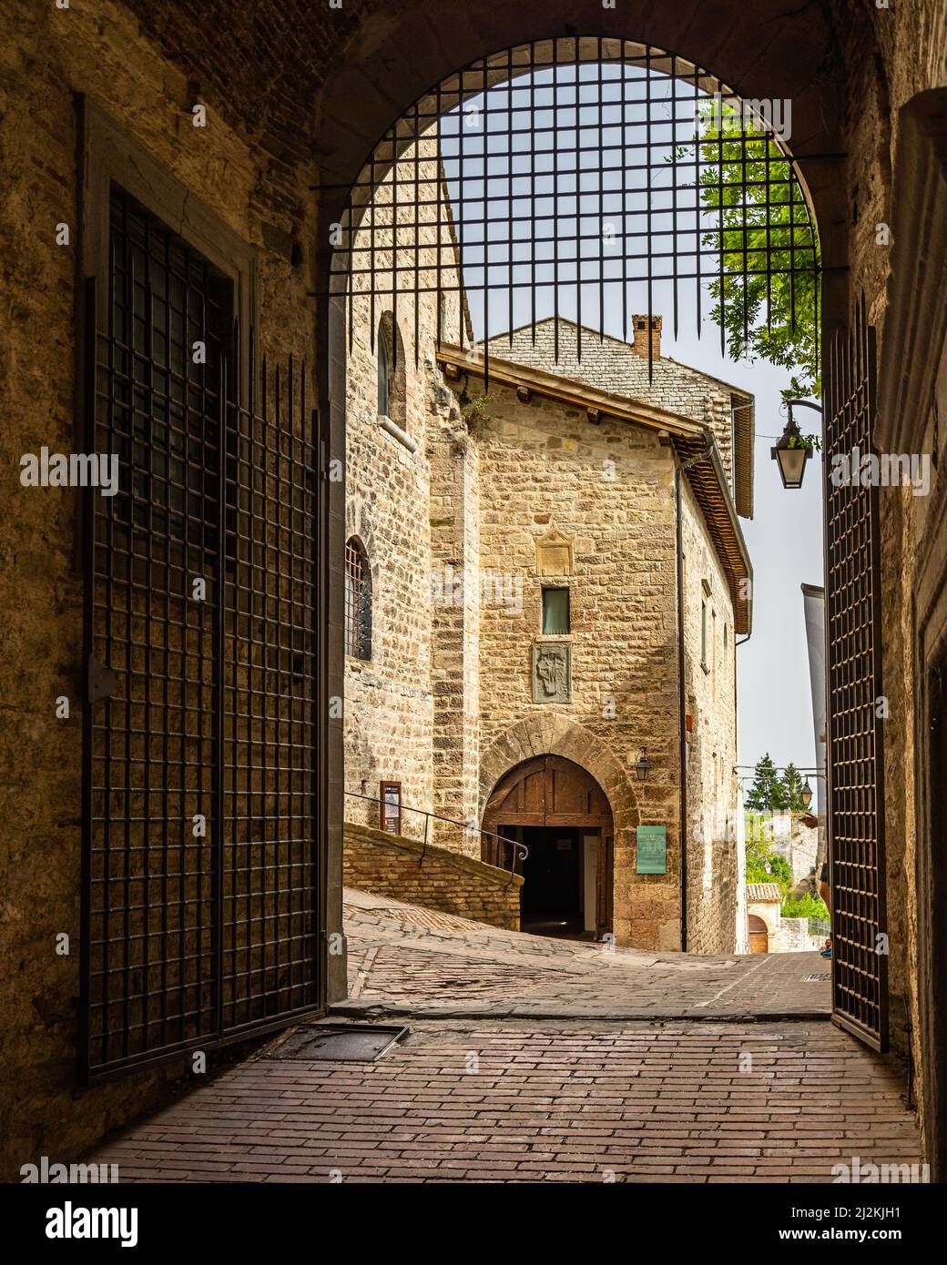 A beautiful shot of a medieval gate and a stone old buildings in Gubbio ...