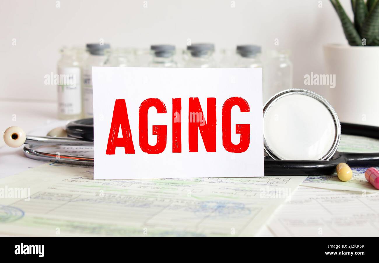Doctor holding a card with text AGING, medical concept Stock Photo - Alamy