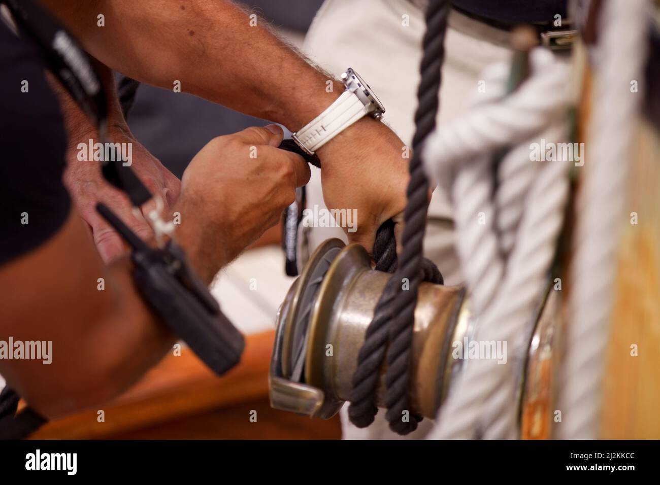 A sailor's hand adjusting ropes to hoist the sails of a boat Stock ...