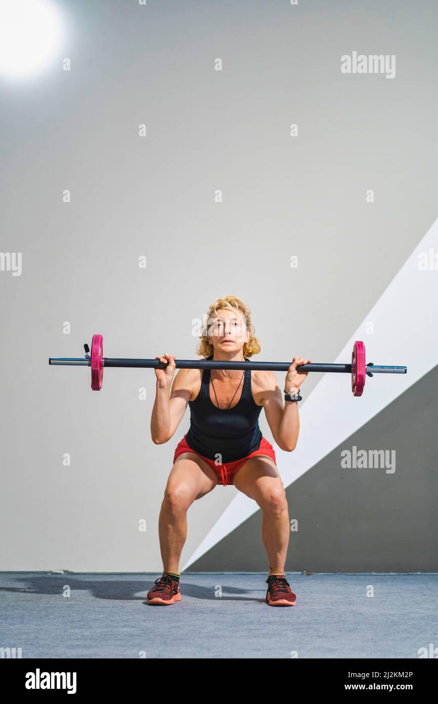 Real young mature caucasian woman in a sport wear in a gym with a ...