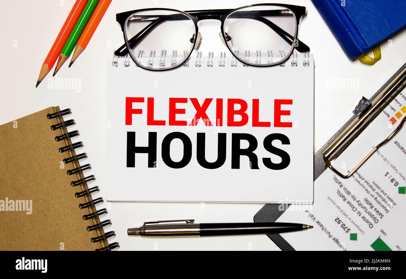 Closeup on businessman holding a card with text FLEXIBLE HOURS ...
