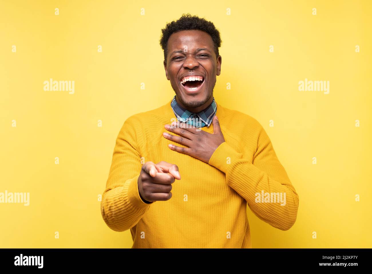 Laughing young african american man pointing index finger on camera ...