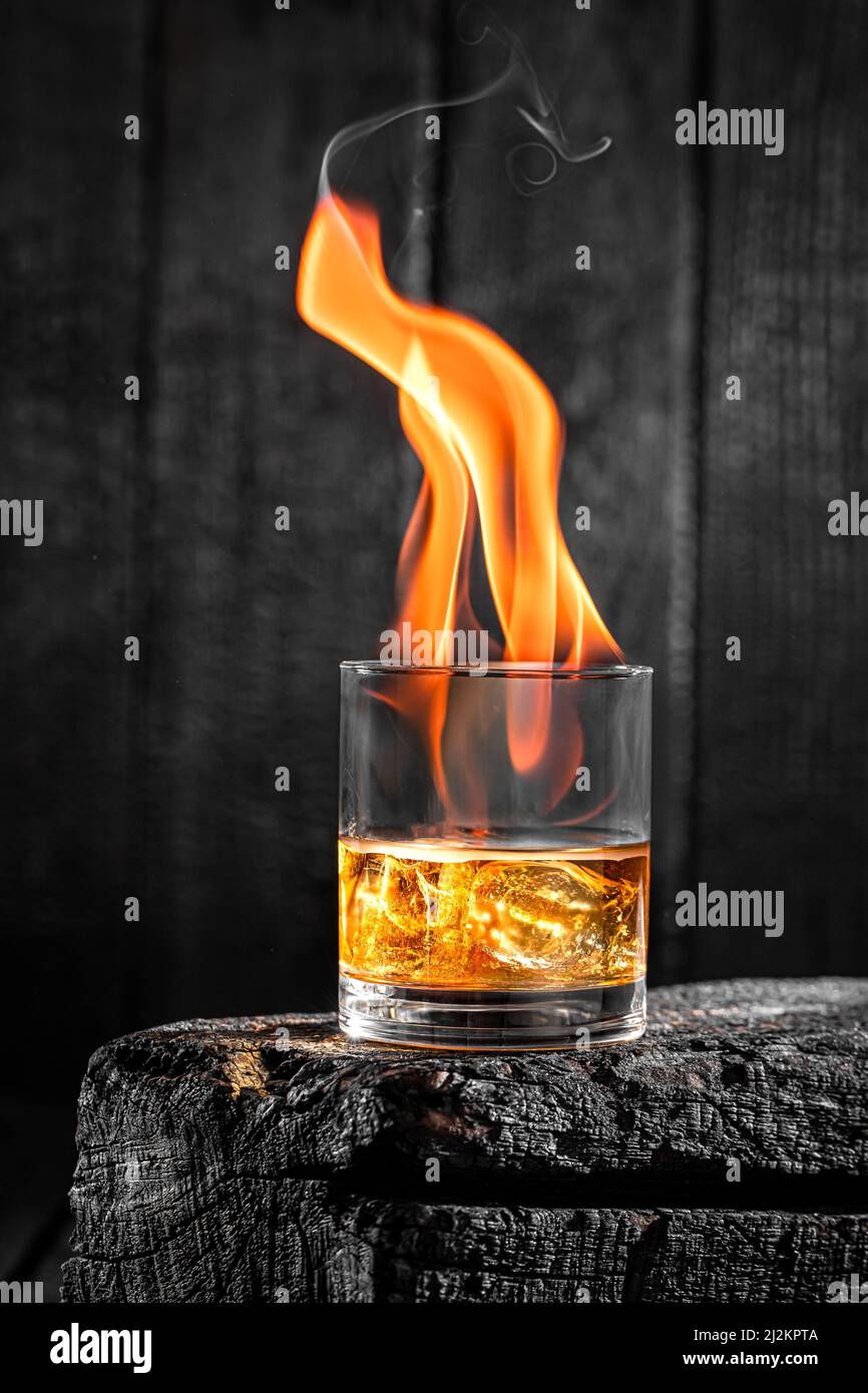 Fire and ice in whisky glass on burnt wood on a burnt black wood Stock ...