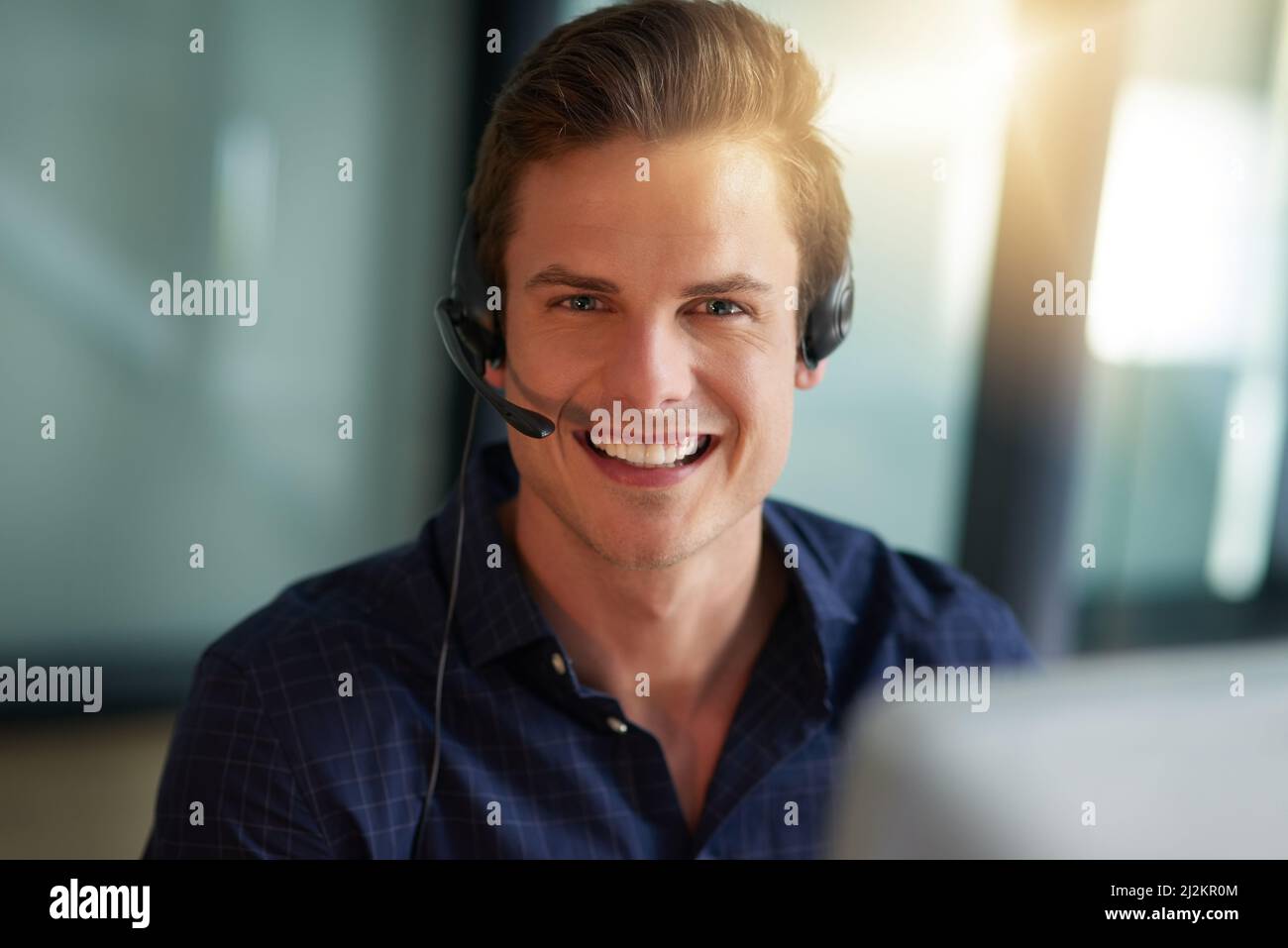 All about assisting the customer. Shot of a young male agent working in ...