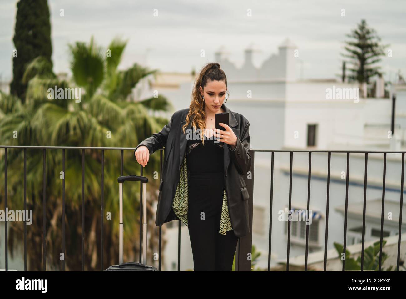 A beautiful Caucasian woman scrolling down her phone by a metallic ...