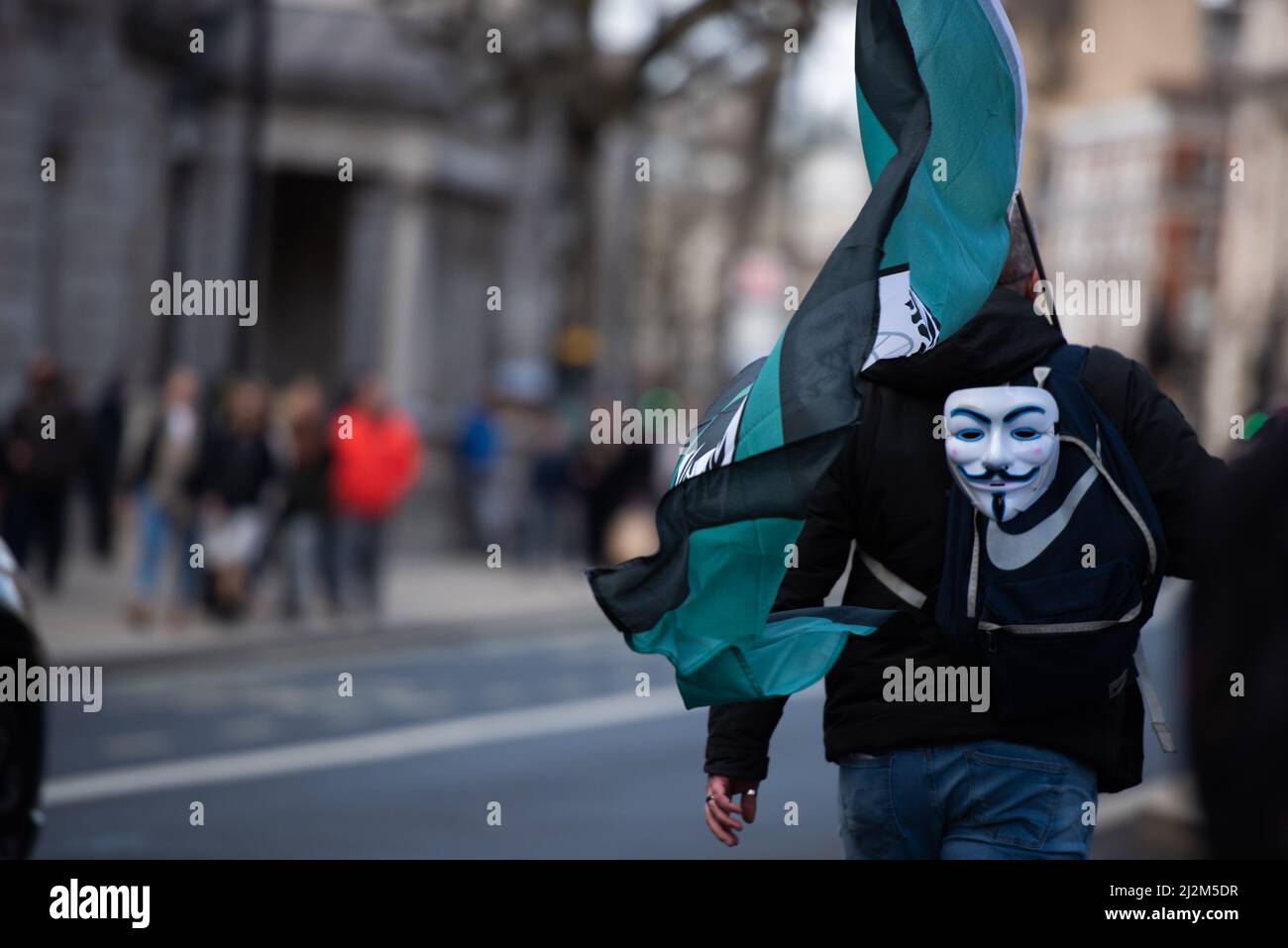 London, UK. 02nd Apr, 2022. A masked protestor carries a large flag ...