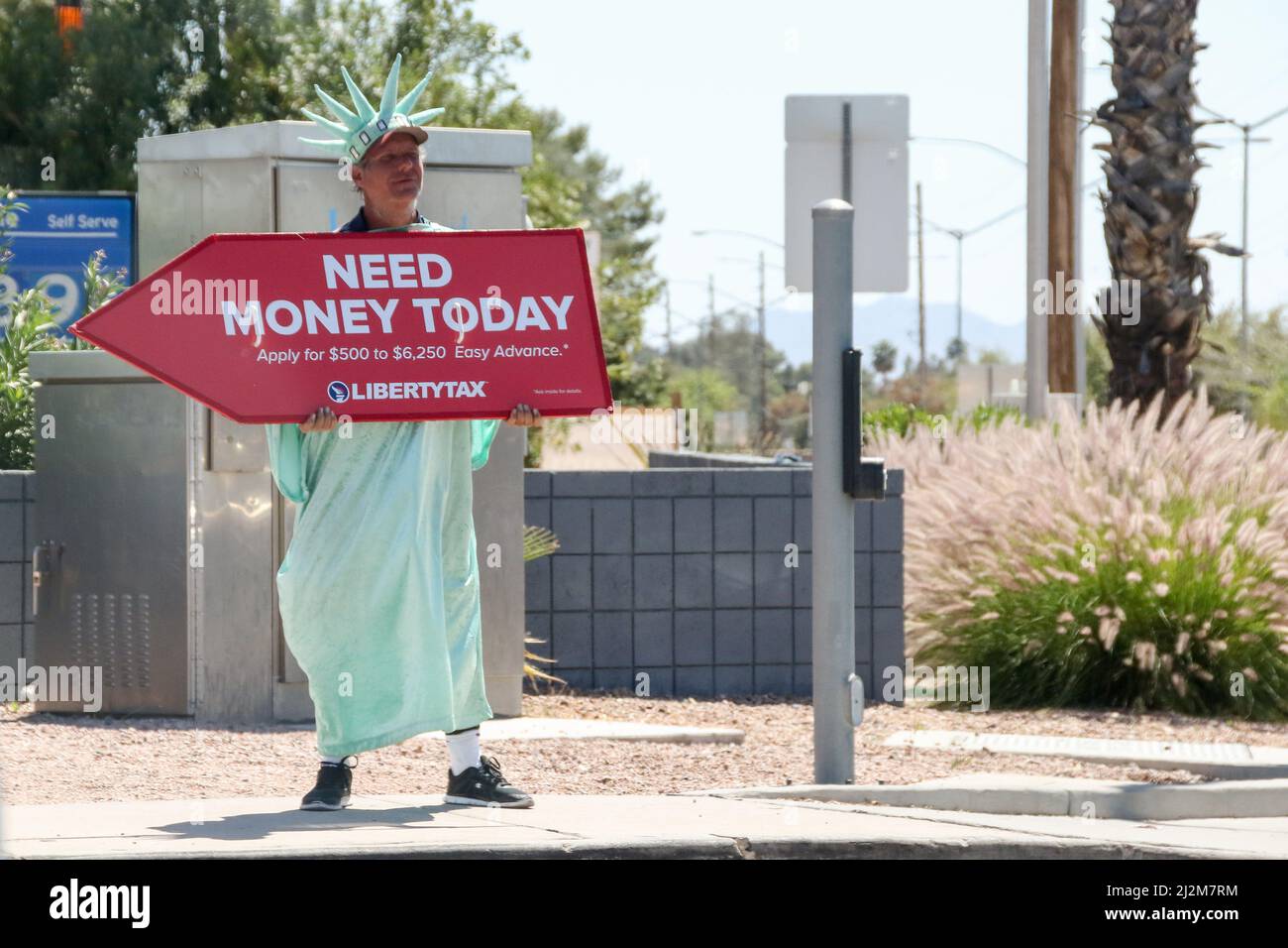Mesa, USA. 01st Apr, 2022. A sign spinner dressed in a Statue of ...