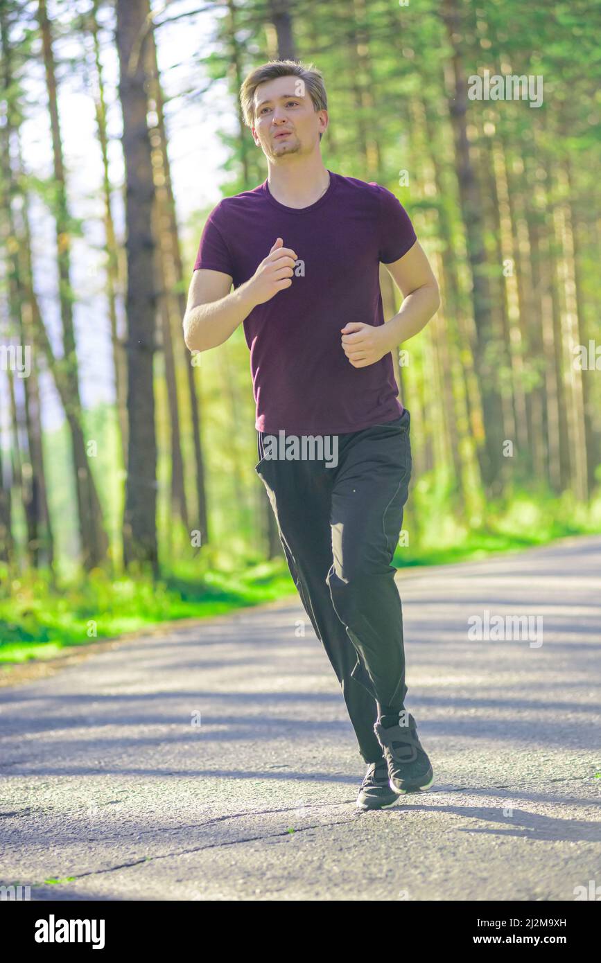 Running man jogging in city park at beautiful summer day. Sport fitness ...