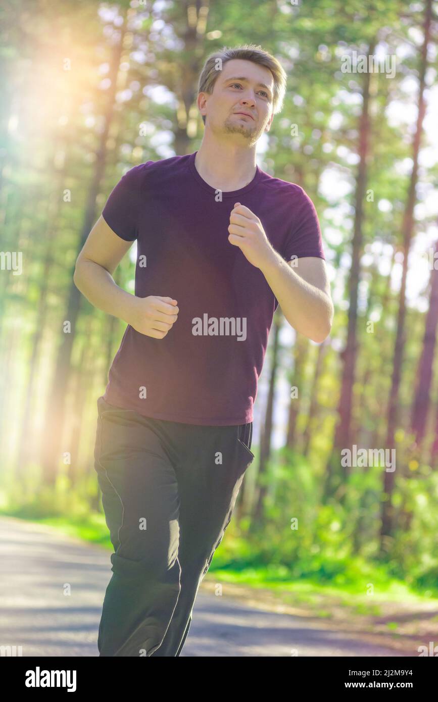 Running man jogging in city park at beautiful summer day. Sport fitness ...