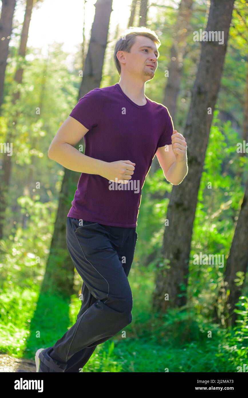 Running man jogging in city park at beautiful summer day. Sport fitness ...