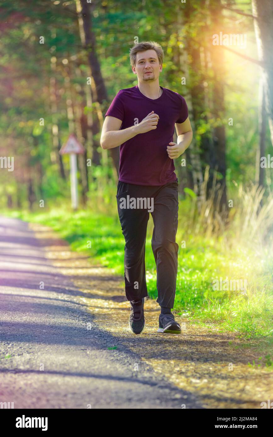 Running man jogging in city park at beautiful summer day. Sport fitness ...