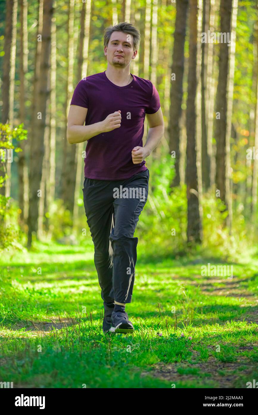 Running man jogging in city park at beautiful summer day. Sport fitness ...