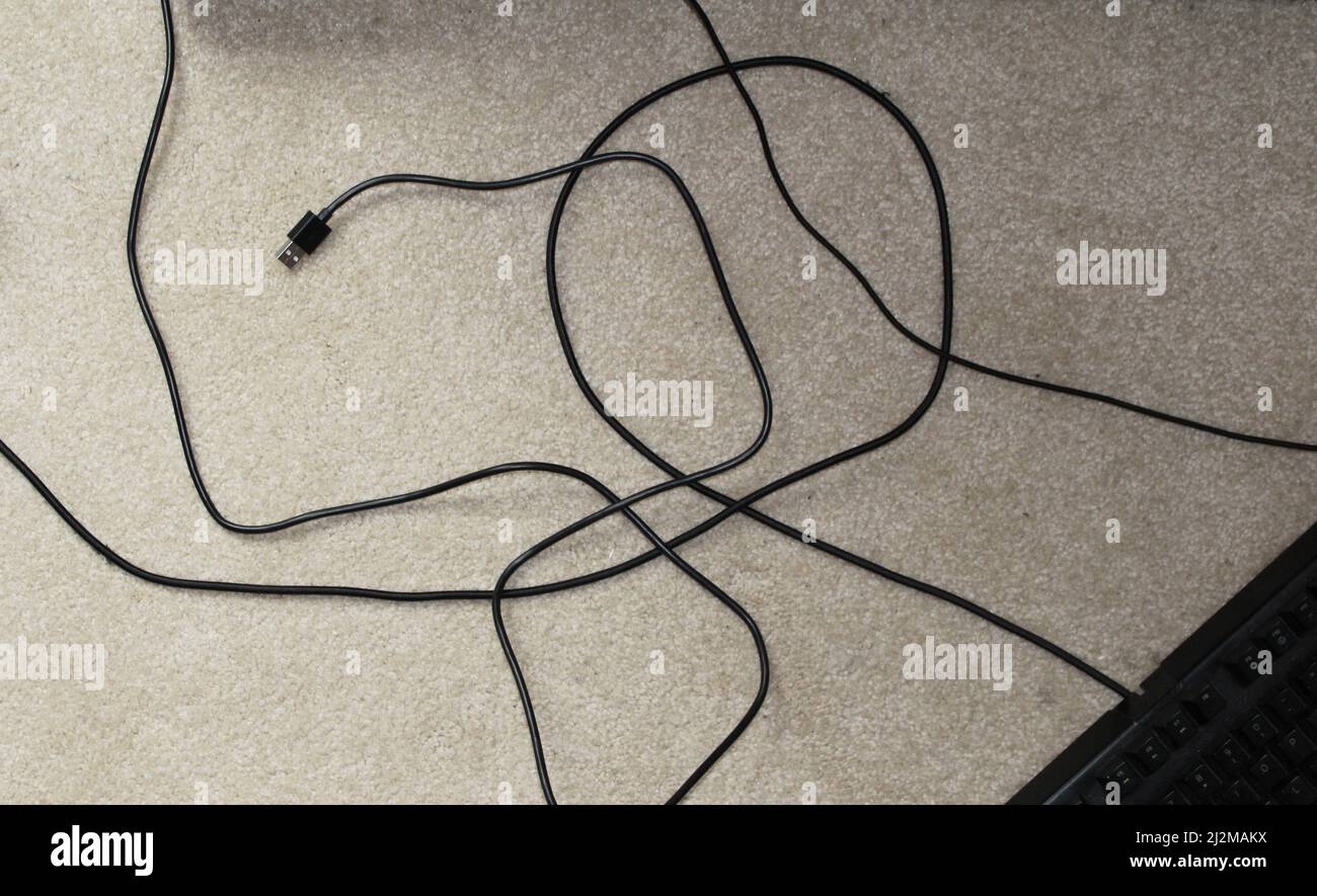 A Tangle of Black Wires on a Tan Carpet Stock Photo - Alamy