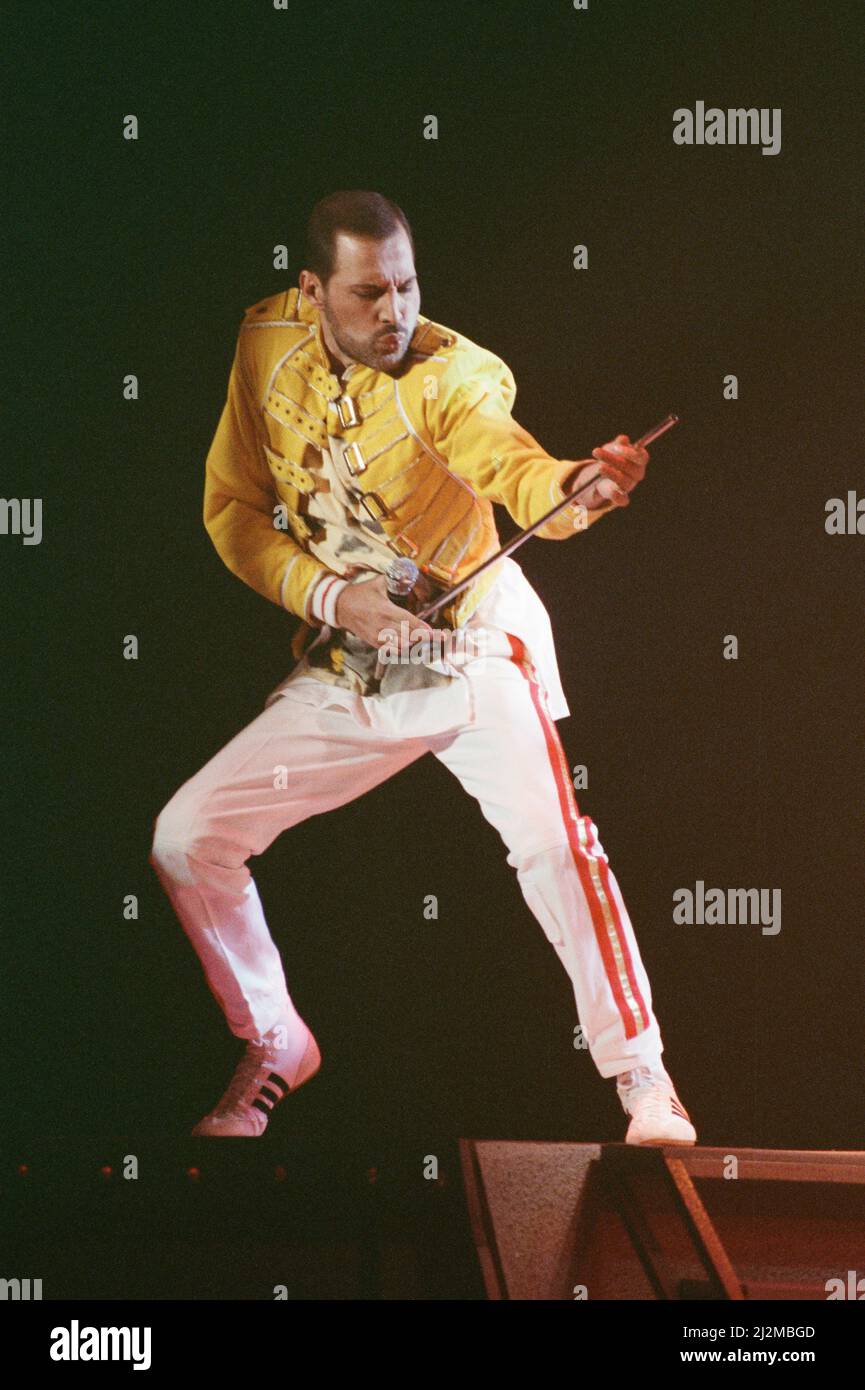 Freddie Mercury, lead singer of rock group Queen, performing on stage ...