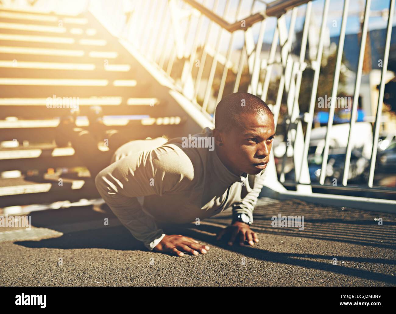 Focused on what lies ahead. Shot of a young sporty man doing push-ups ...