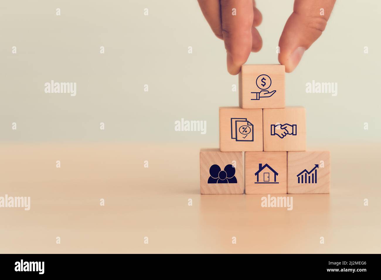 Wealth management concept. Man put wooden cube on the top with money ...