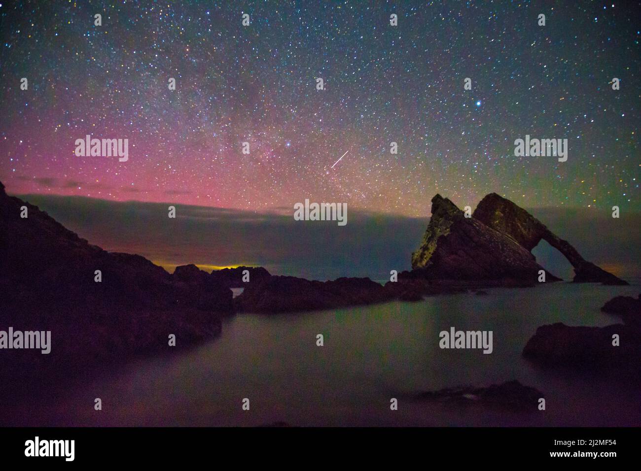 bow fiddle rock with shooting star and northern lights Stock Photo - Alamy