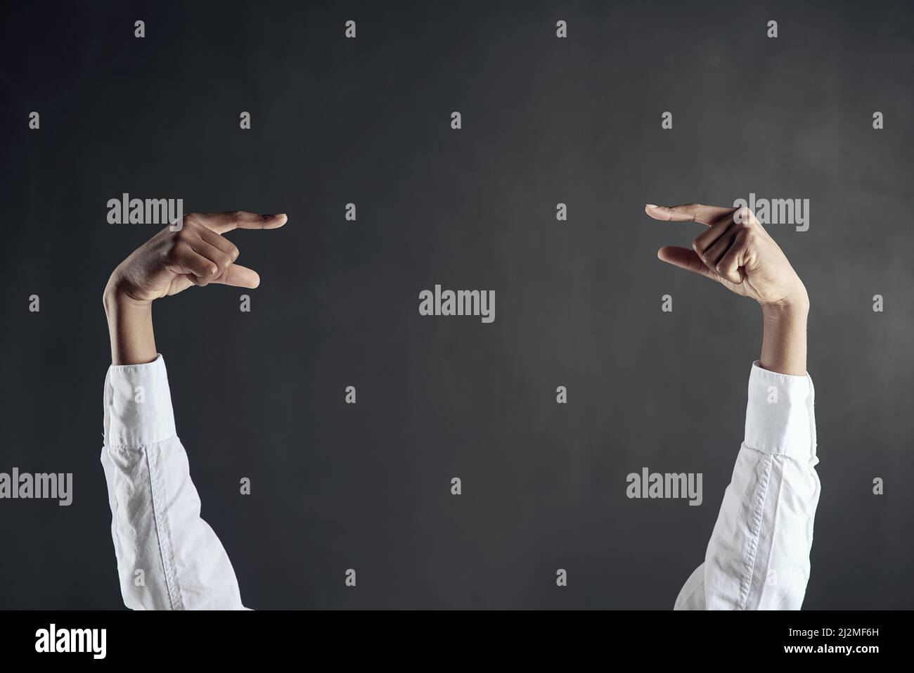 Check this out. Shot of hands pointing to each other against a dark ...