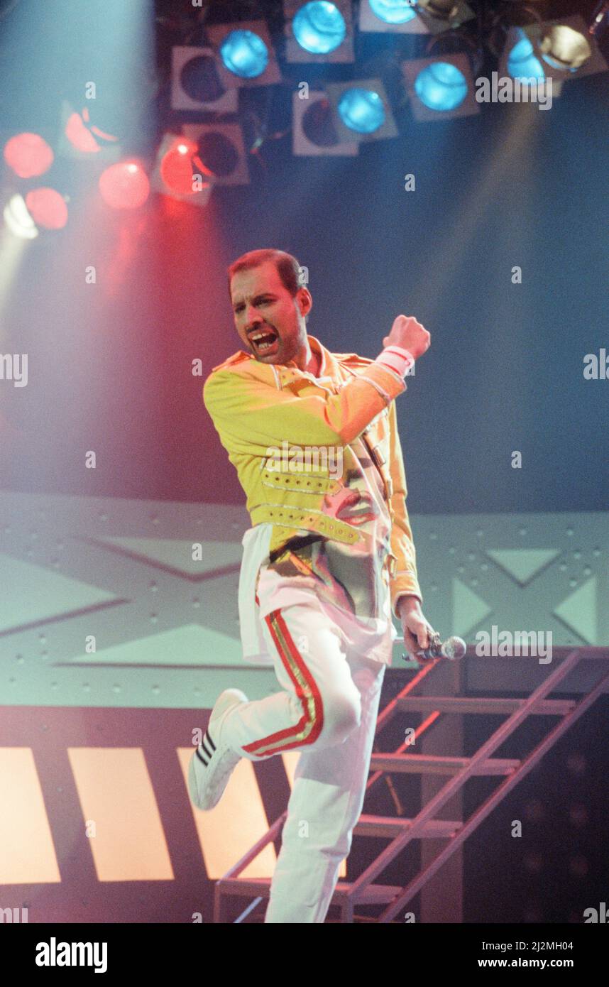 Freddie Mercury, lead singer of rock group Queen, performing on stage ...