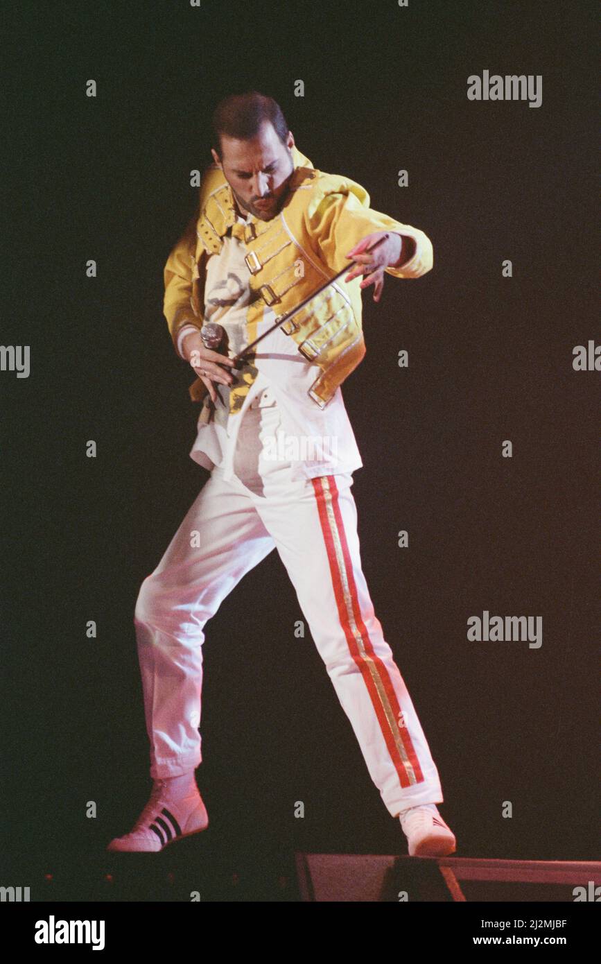Freddie Mercury, lead singer of rock group Queen, performing on stage ...