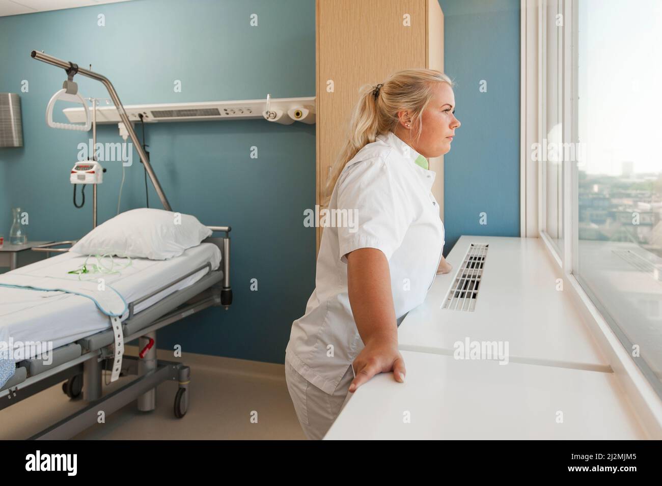 Nurse looking out a hospital window Stock Photo - Alamy
