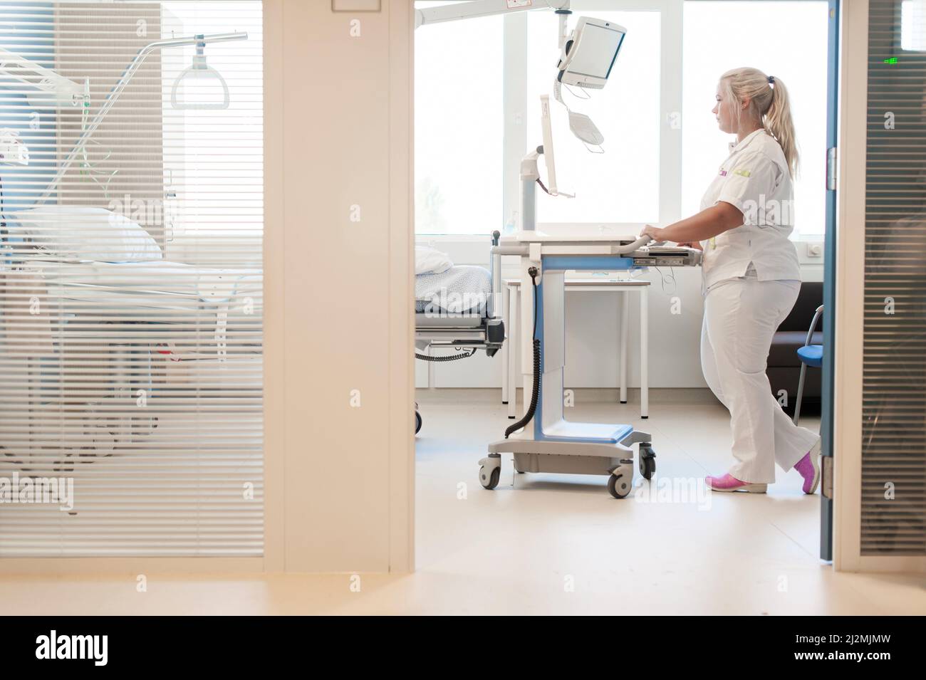 Nurse behind a computer on wheels Stock Photo - Alamy