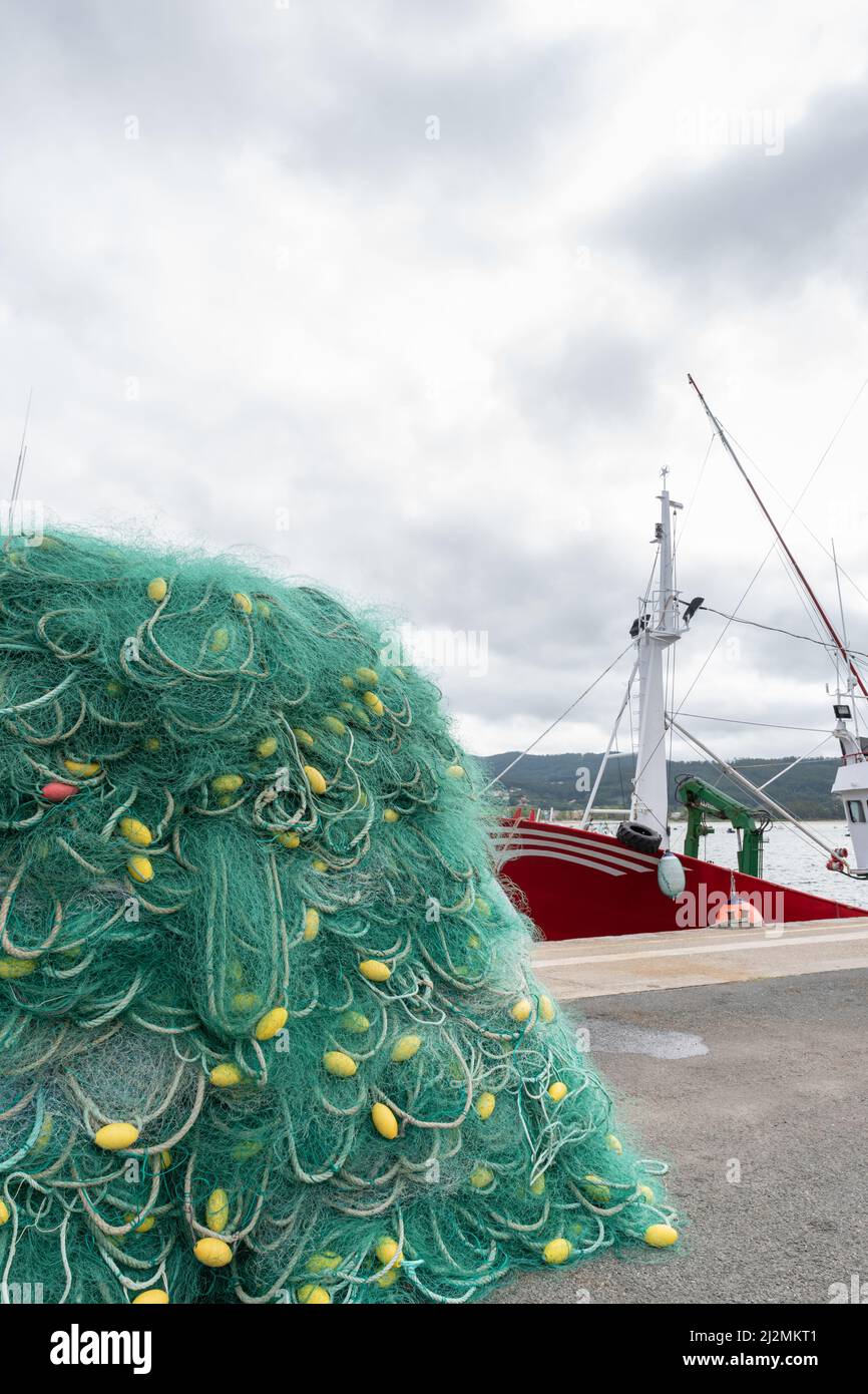 Green fishing net with yellow float and boat background in the seaport ...