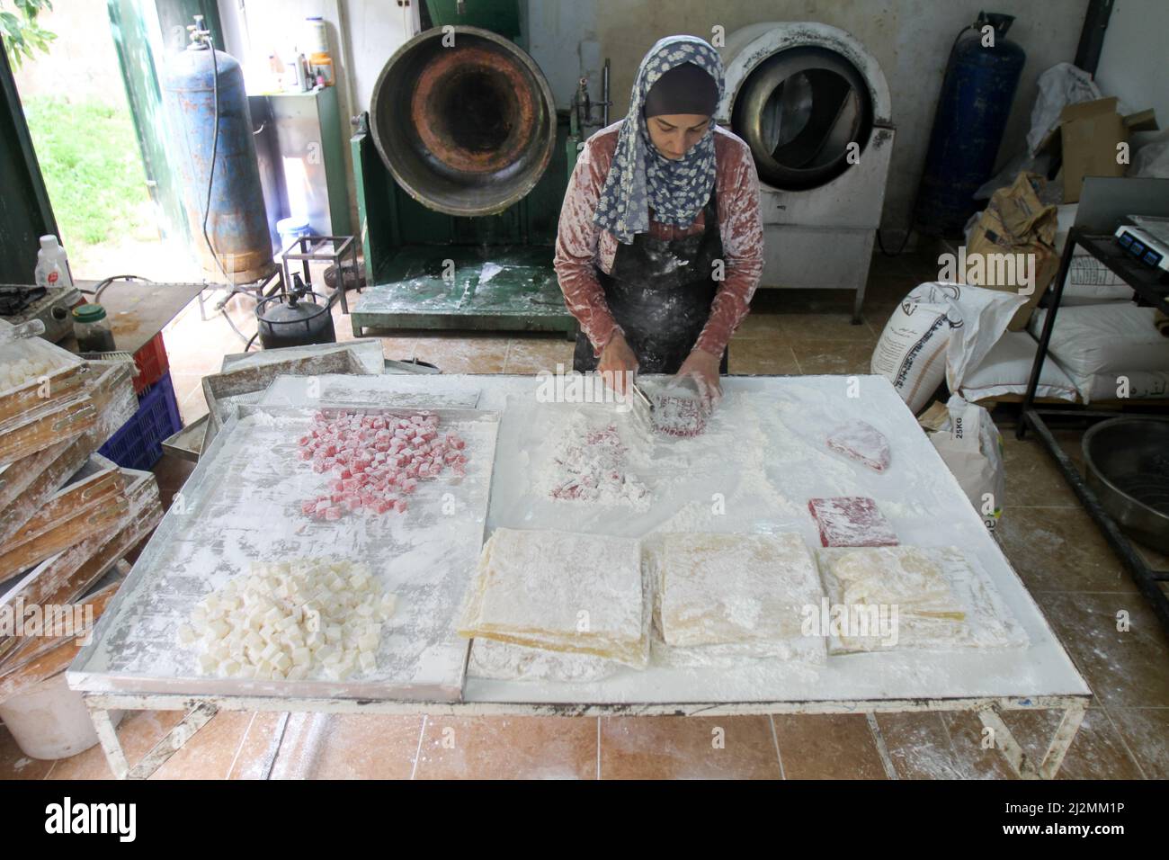 A Palestinian woman prepares sweet (halqum), an Iraqi-Turkish dessert ...