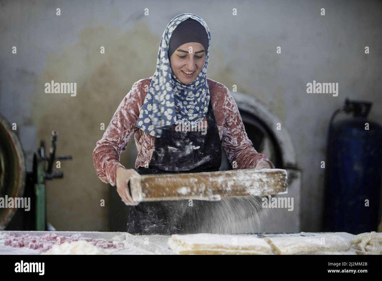 A Palestinian woman prepares sweet (halqum), an Iraqi-Turkish dessert ...