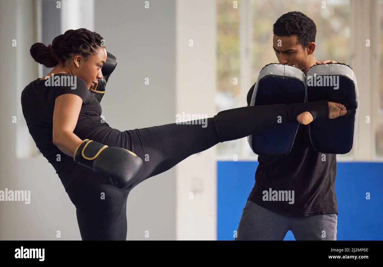 Kickboxing is the best form of dynamic exercise. Shot of a young woman ...