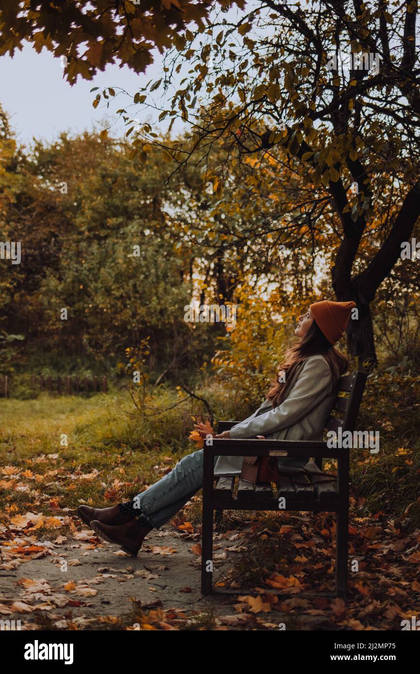 Young woman sitting alone on park bench hi-res stock photography and ...