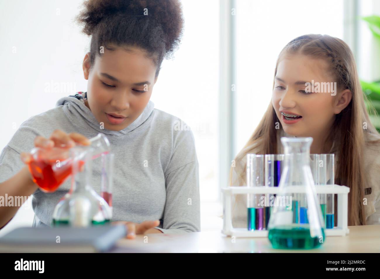 Young teacher teaching group student about science and test chemical ...