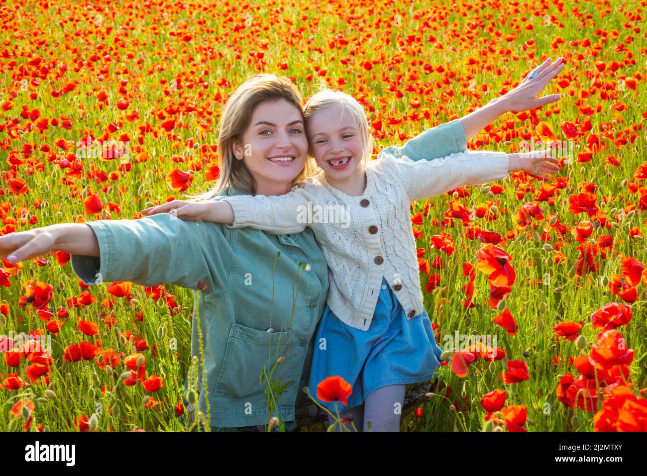 Mother with daughter outdoor in poppy field. Carefree mom and lovely ...