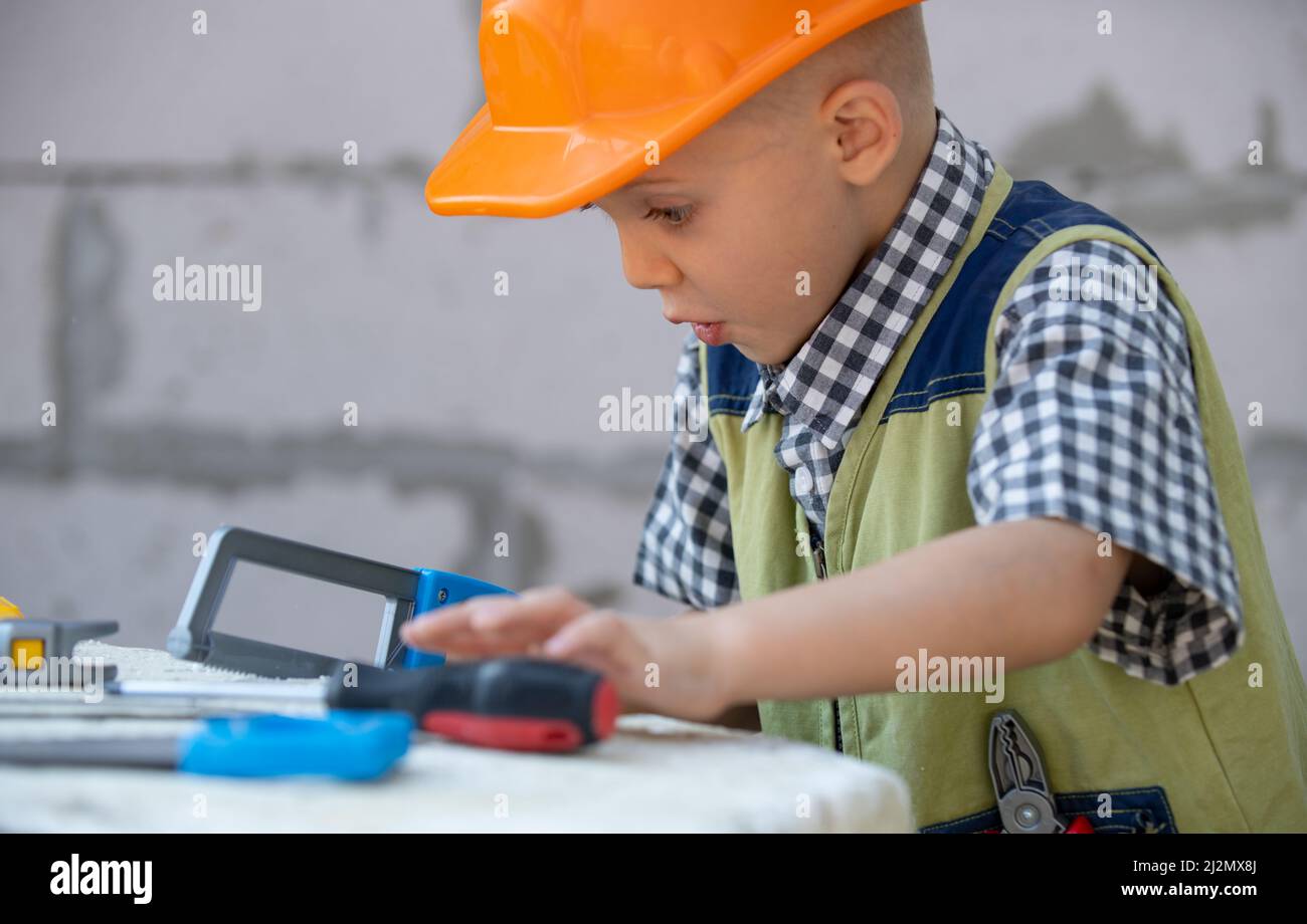 Preschool boy trying to saw, Child sawing on a construction site near ...