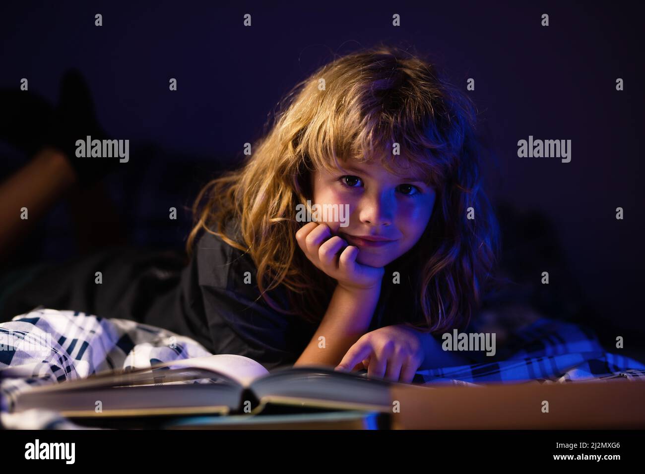Child read fairy tale from book. Child reading a book in bed before ...