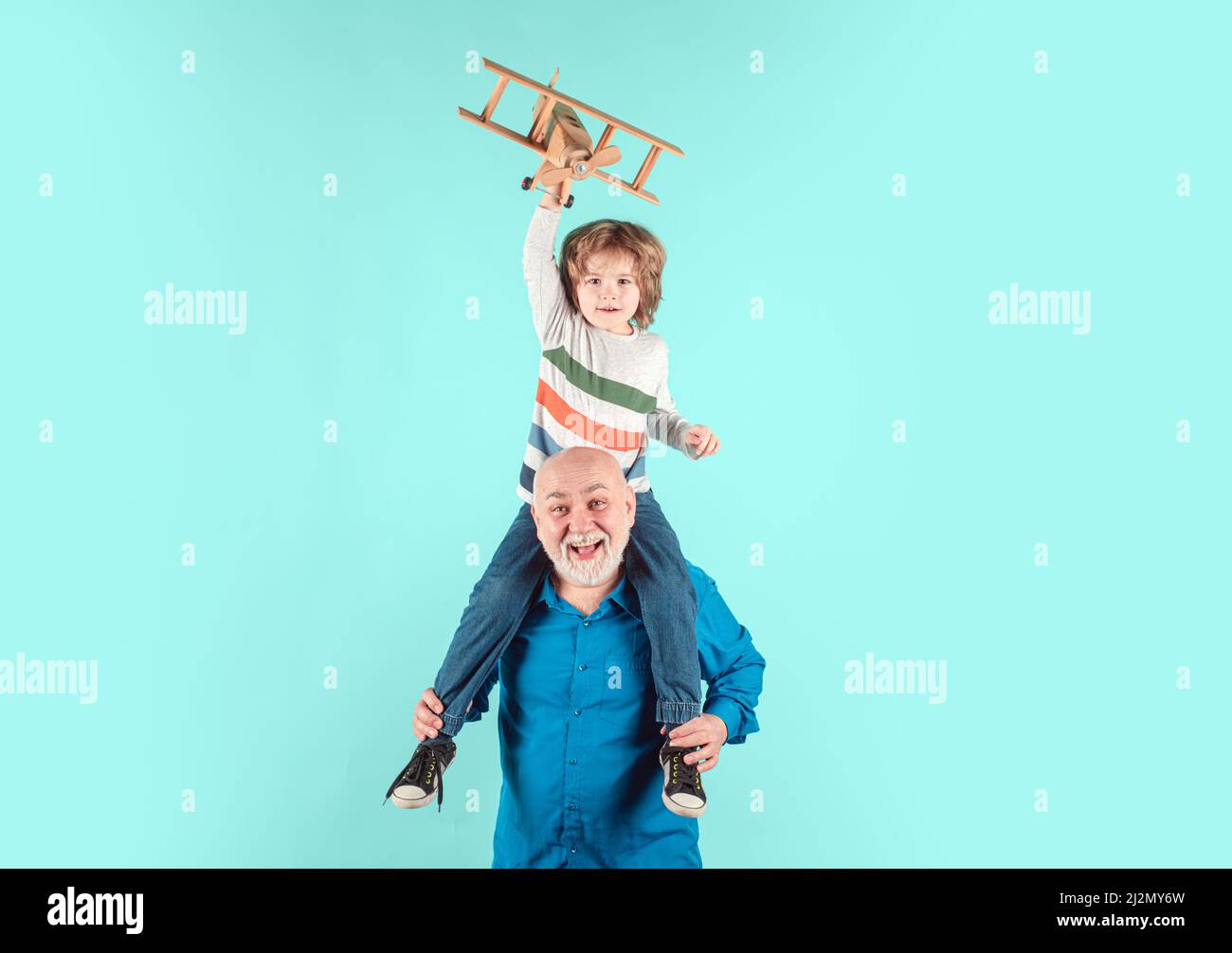 Grandfather and grandson piggyback with toy plane. Men generation ...