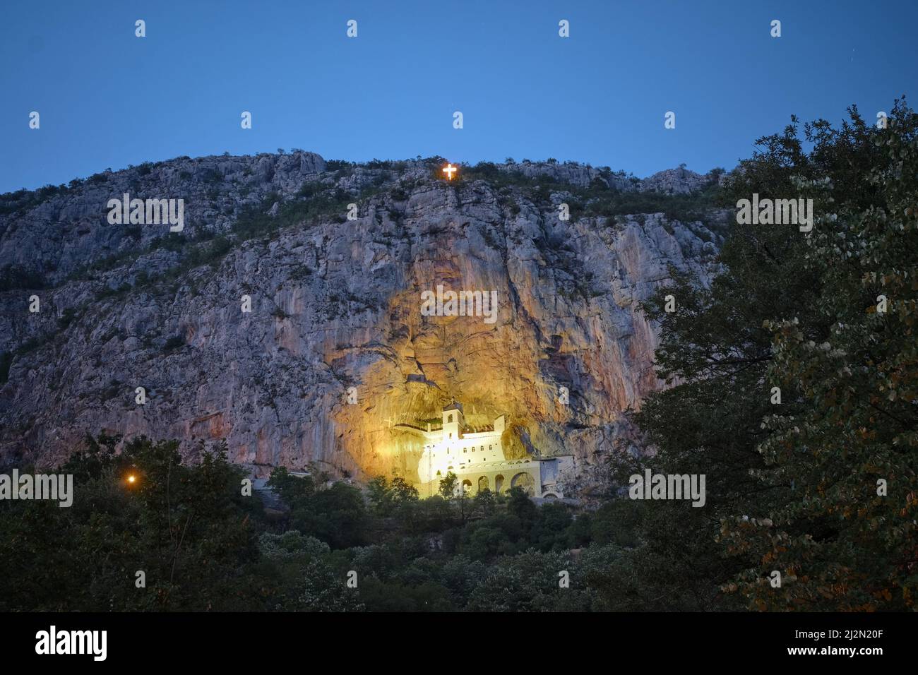 lighting Ostrog Monastery on rocky wall at twilight, Montenegro Stock ...